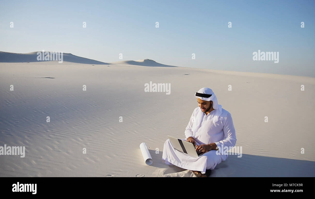 Muslim Arabian UAE Sheikh architect sitting with laptop on sand Stock ...