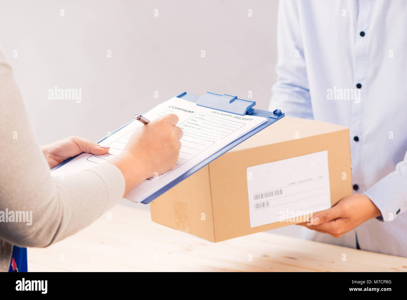 Delivery man presenting receiving form in post office Stock Photo - Alamy