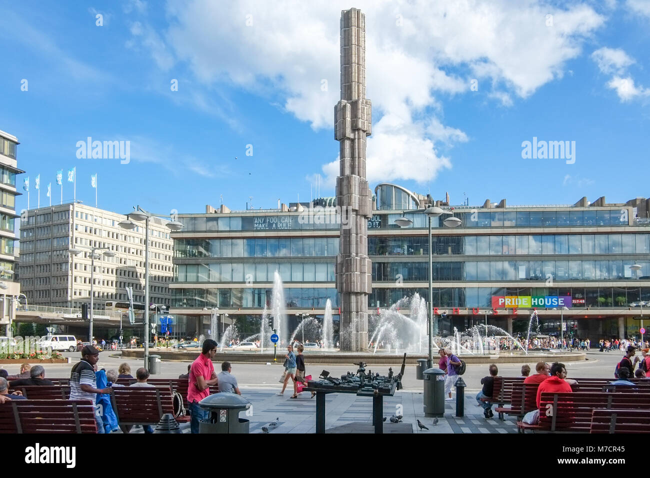 People strolling at Sergel square in Stockholm. The glass obelisk in ...