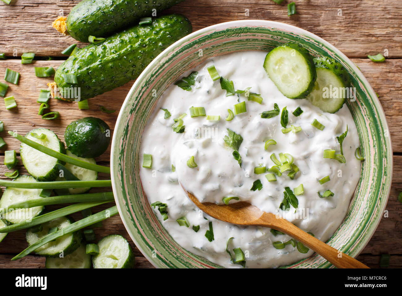 Homemade Indian raita dressing with herbs, spices and cucumber close-up ...