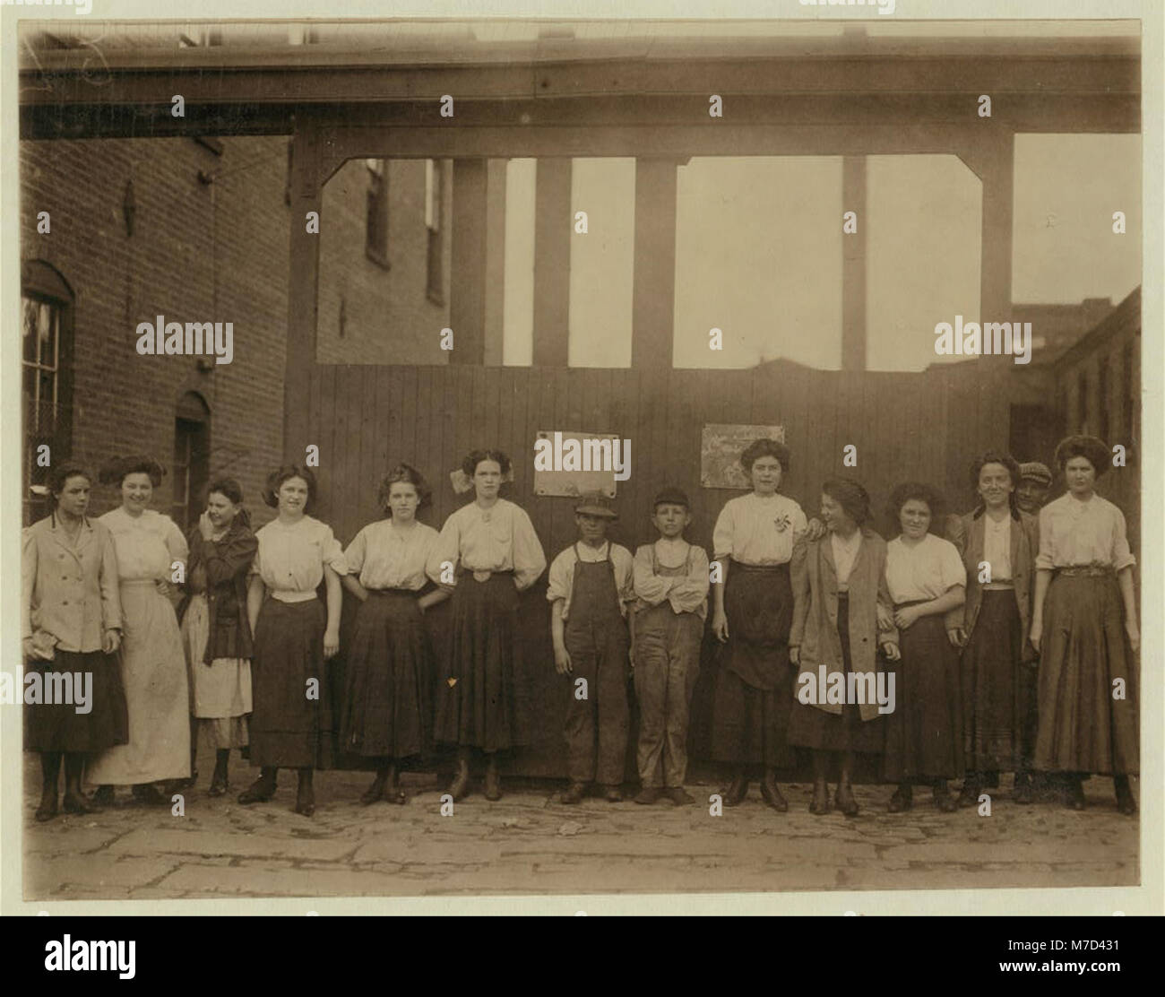 A scene showing groups of workers inside a hand silk mill. The image ...