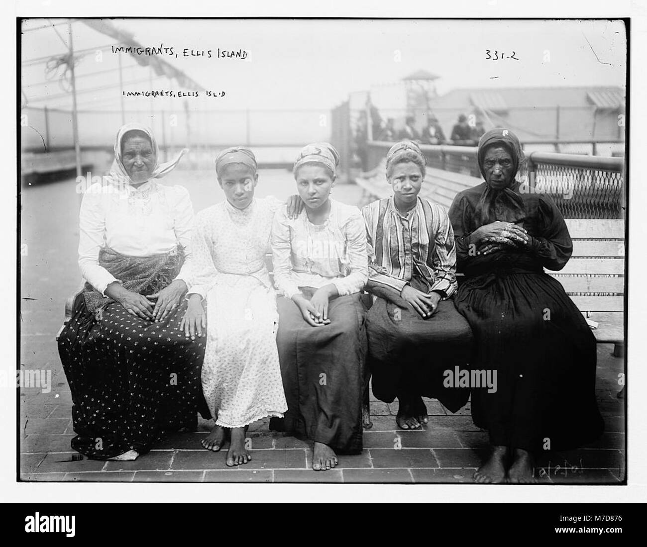 A photograph of immigrants arriving at Ellis Island, the primary port ...