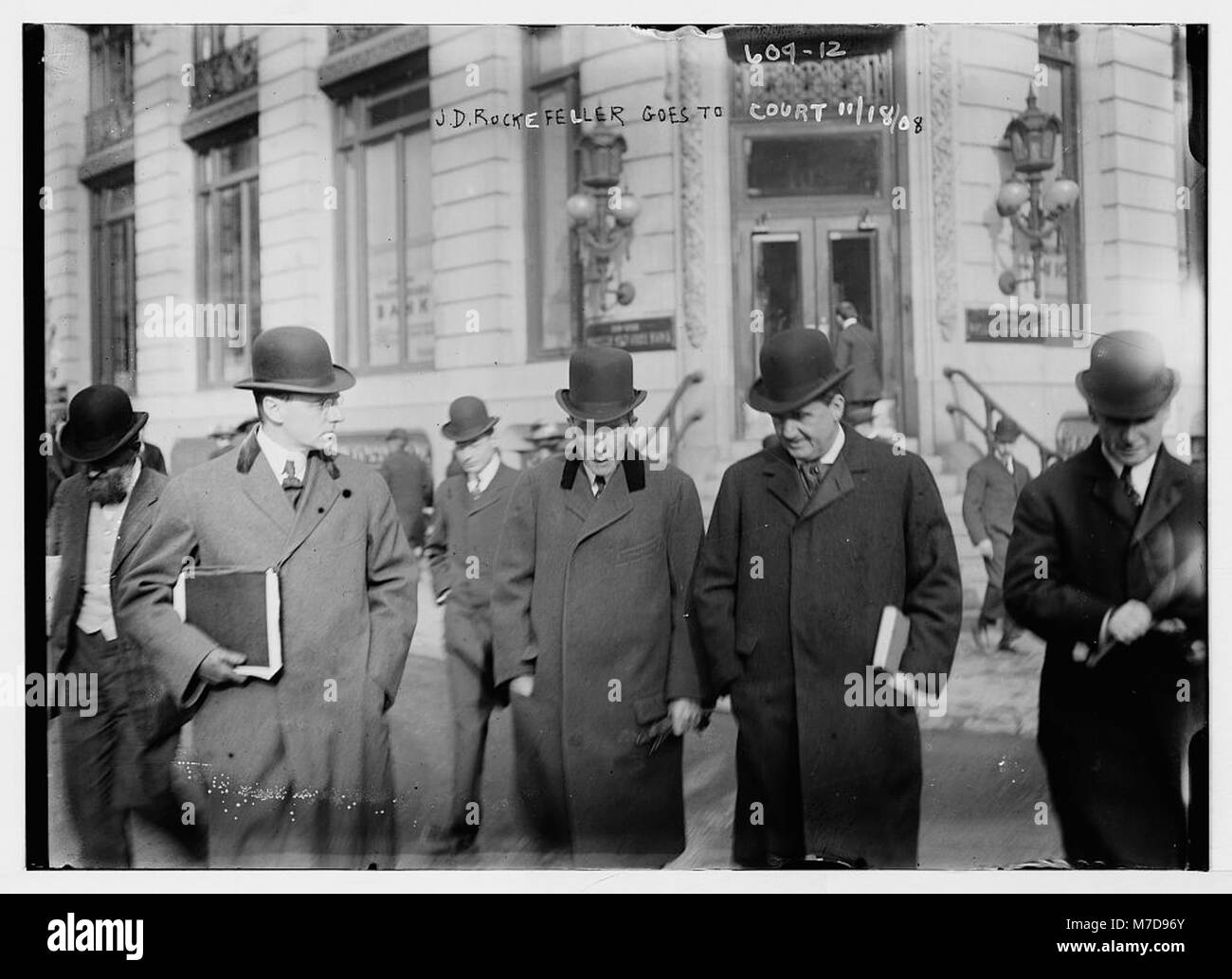 A historical photograph capturing John D. Rockefeller attending court ...