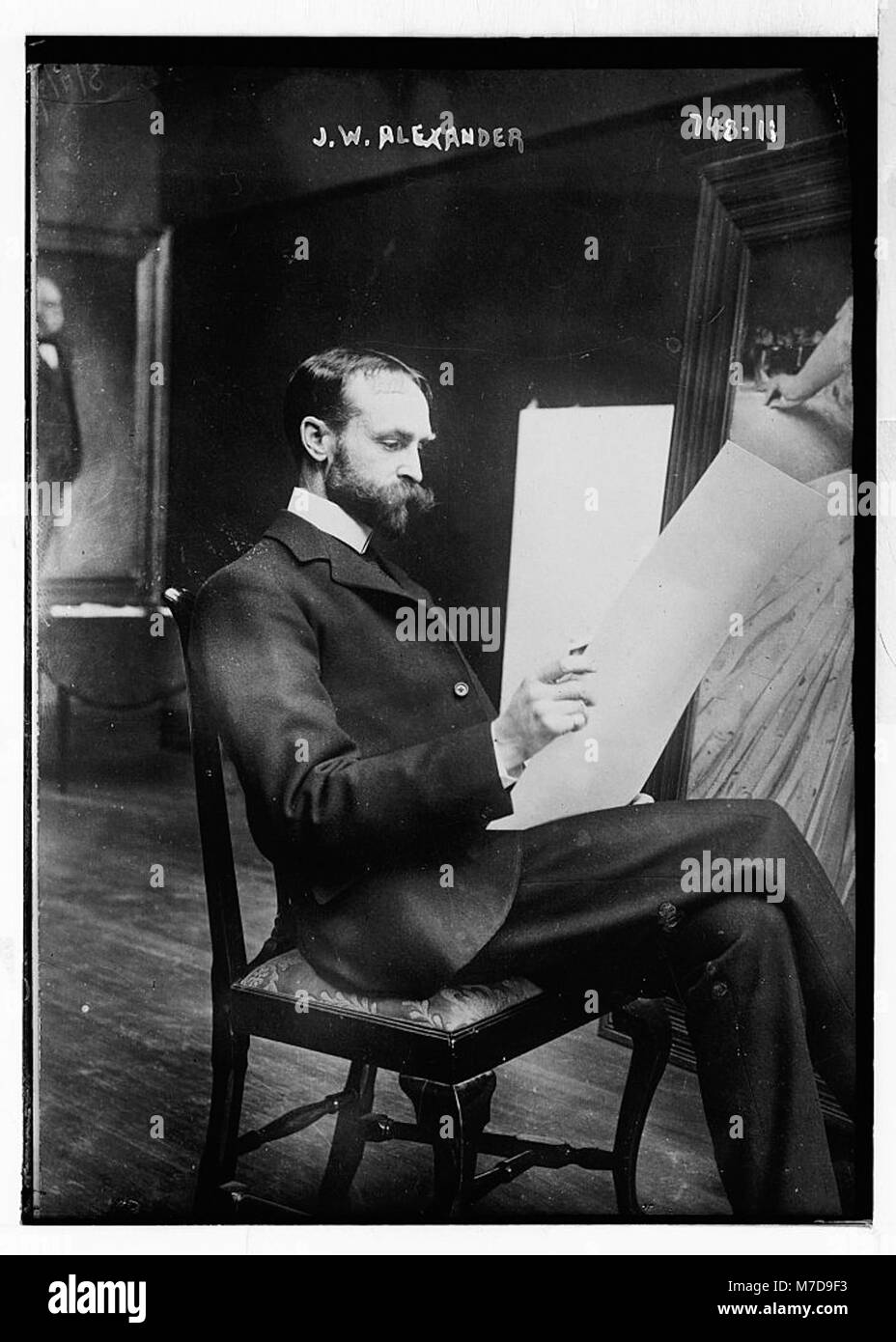 This photograph shows J.W. Alexander seated in a picture gallery, a ...