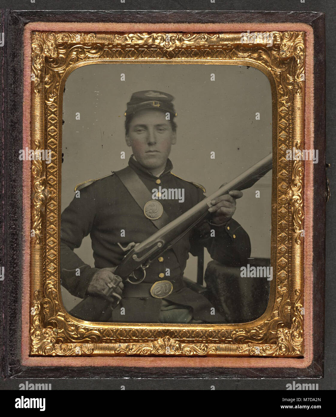 A photograph of James McGrail, a Union soldier, seated with his musket ...