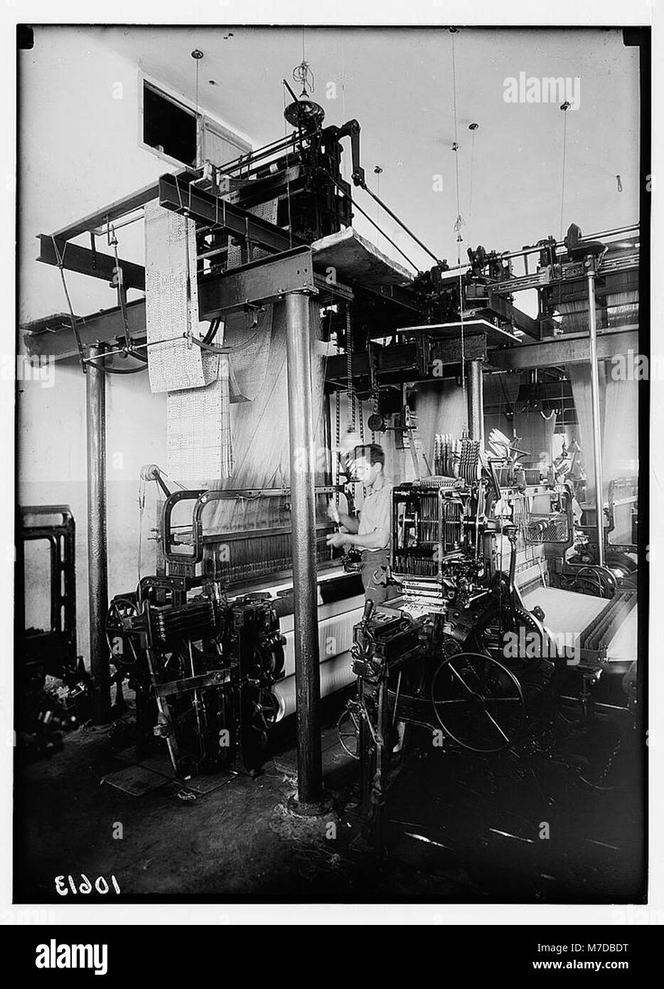 A photograph showing a Jacquard silk loom in operation at the 'Meshi ...