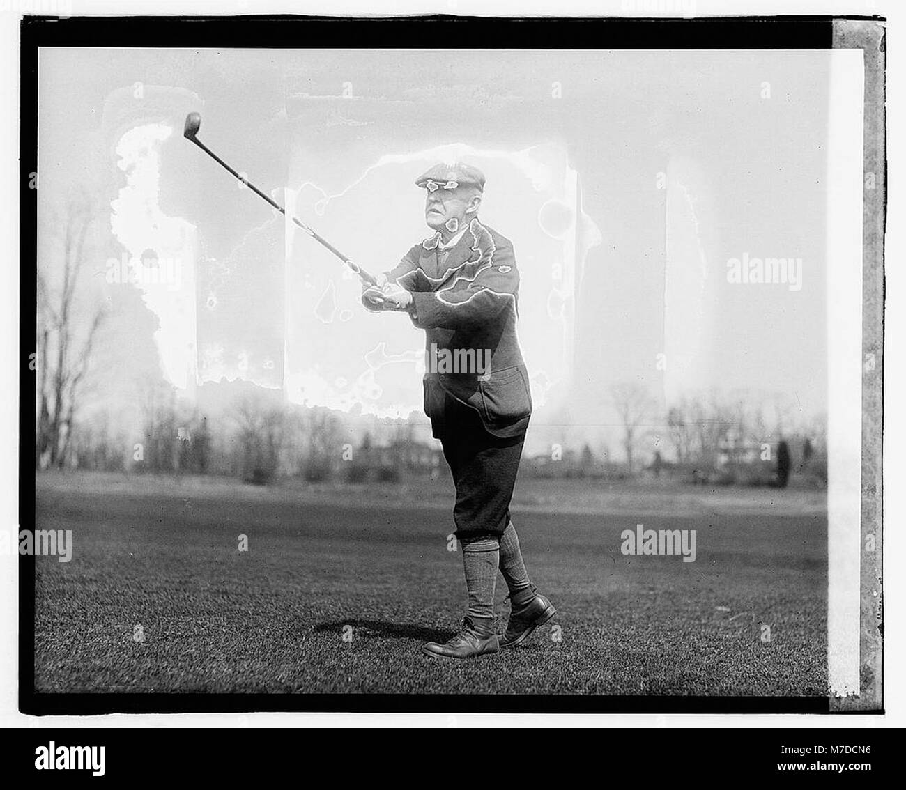A portrait of Judge John Barton Payne, photographed in a golf setting ...