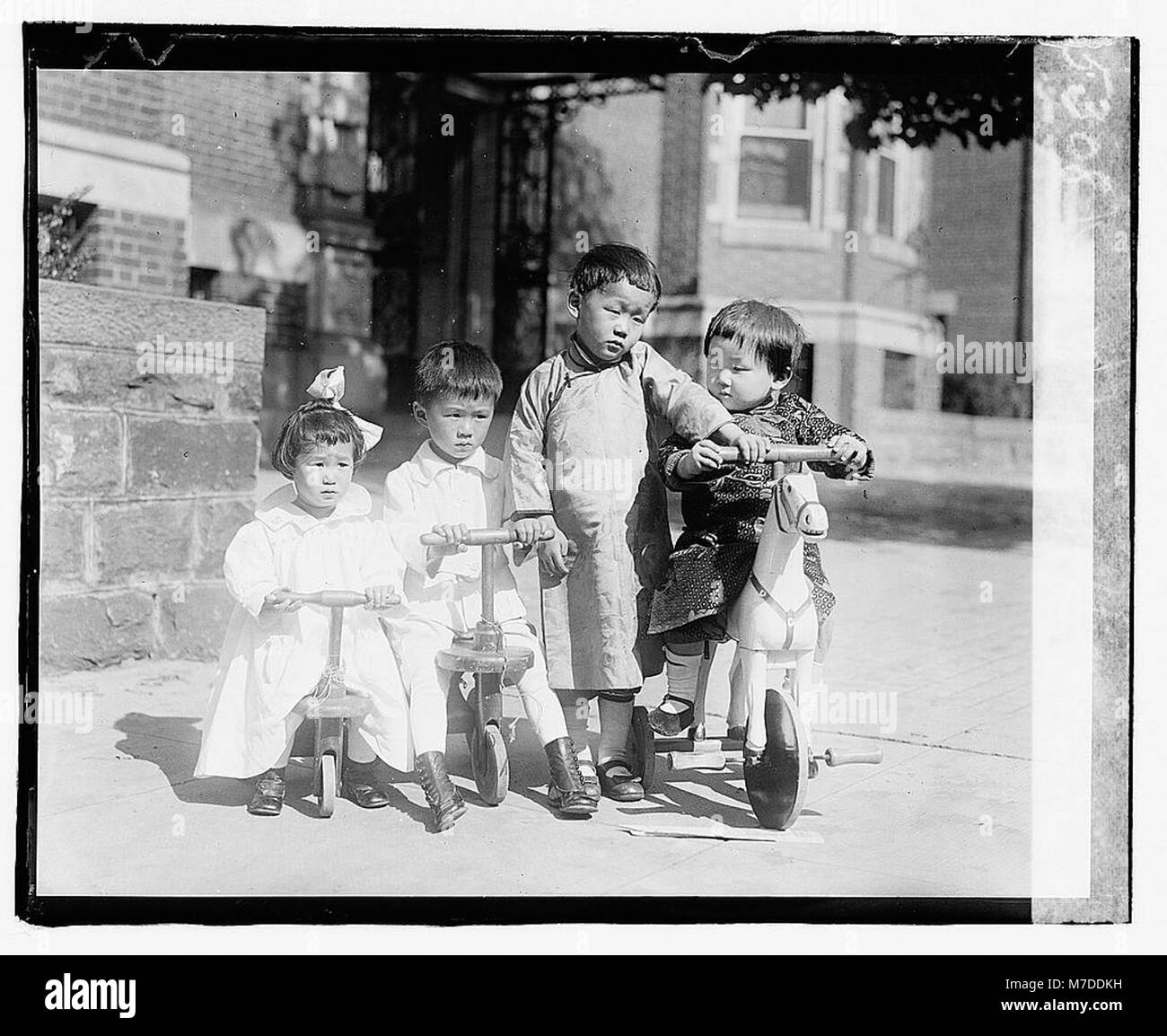 A photograph of two children, Koo and Sze, likely siblings, capturing a ...