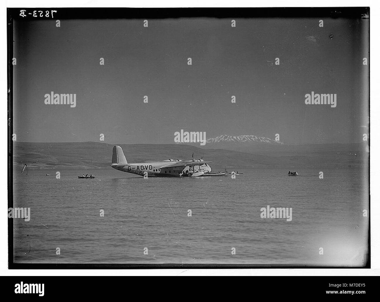A photograph of the flying boat 'Clio' on a lake, with the snow-capped ...