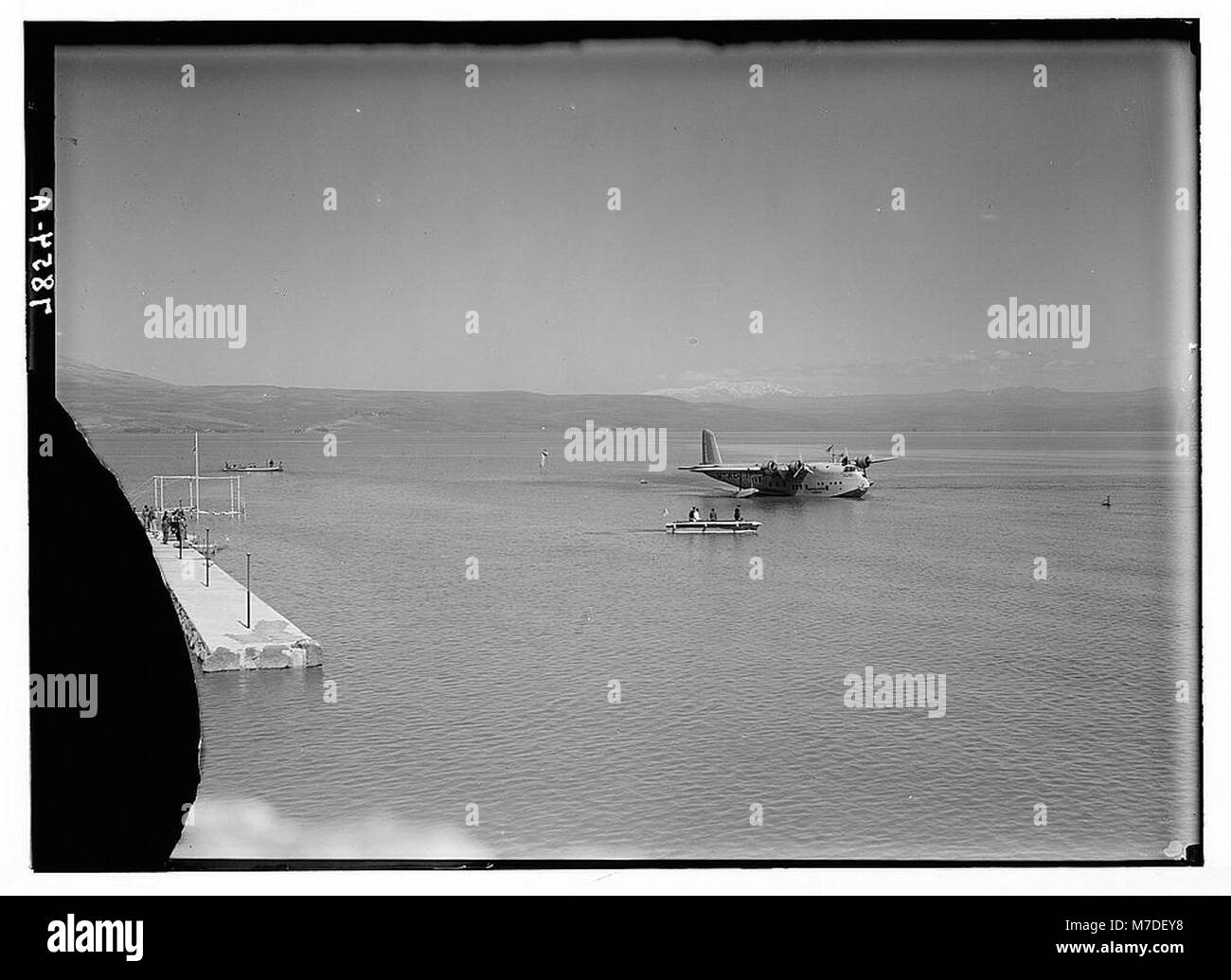 The flying boat 'Clio' takes off from a lake, with the snow-capped ...