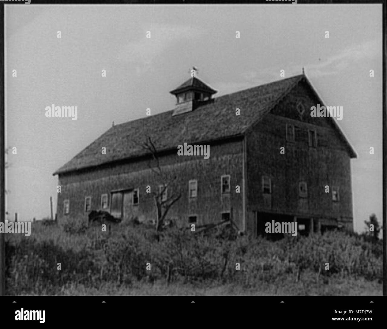 The image shows a traditional barn in Massachusetts, reflecting the ...