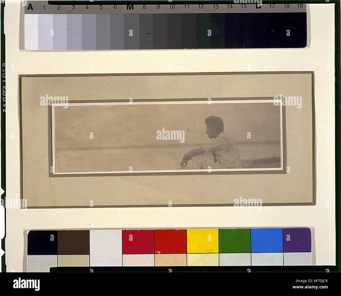 Maynard White is seated on the seashore, captured in profile ...