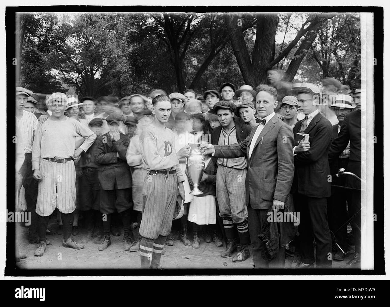 A photograph of a sports team member receiving a trophy, capturing a ...