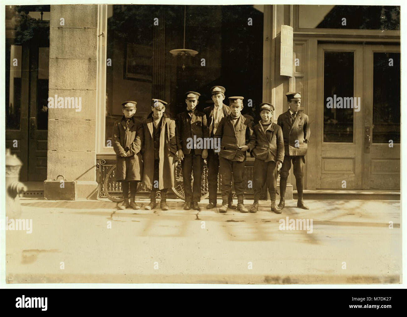 A historical photograph depicting messenger boys at work late into the ...