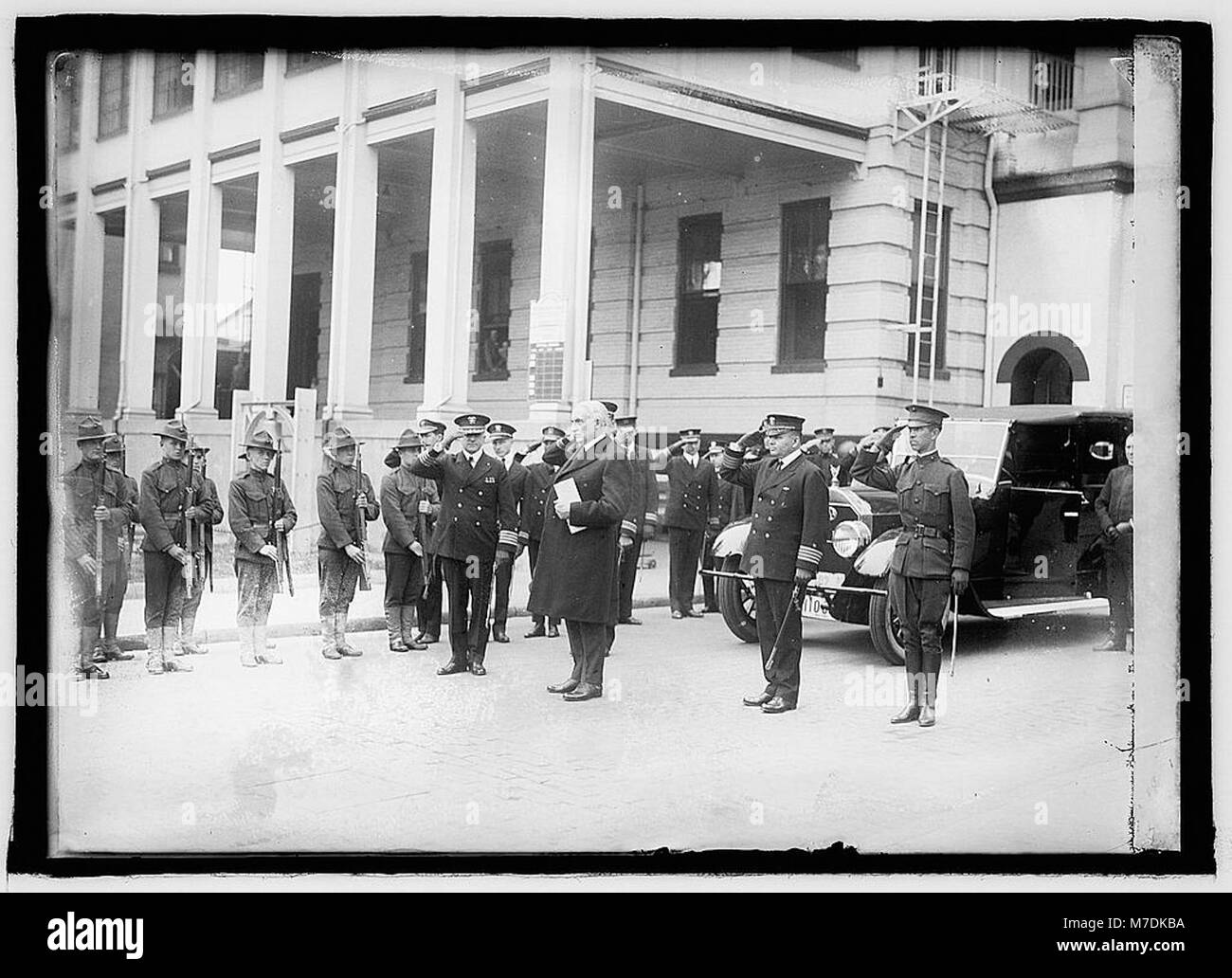 A military group salutes President Harding, capturing a moment of ...