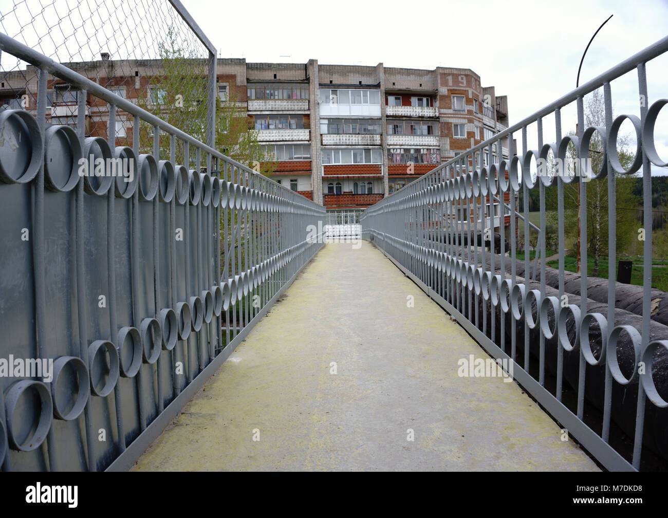 End of pedestrian bridge over suburban road and curved continuation of ...