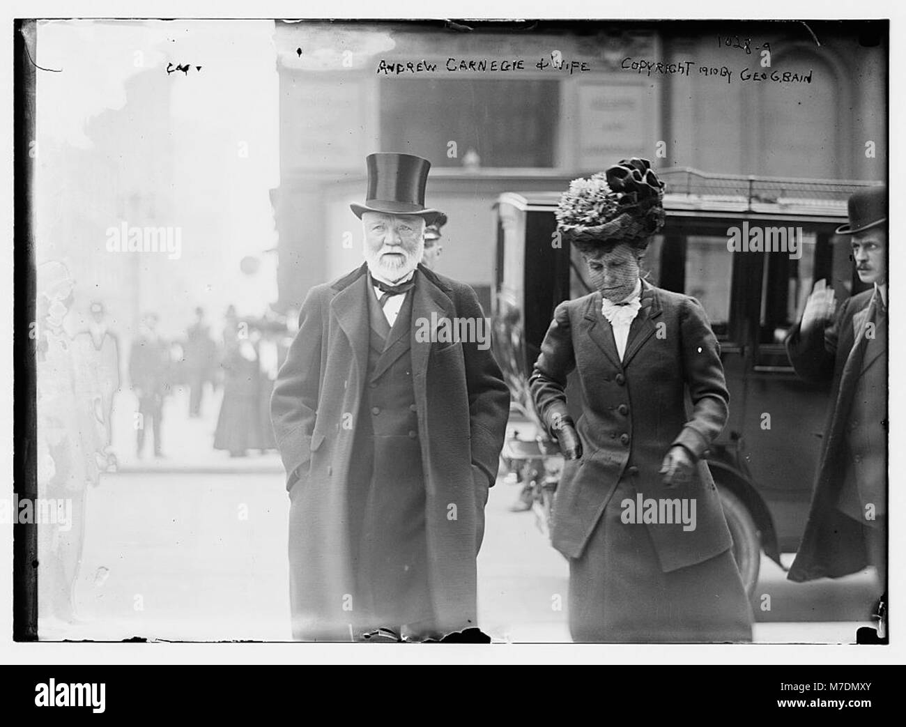 A photograph of Mr. and Mrs. Andrew Carnegie walking down a street. The ...