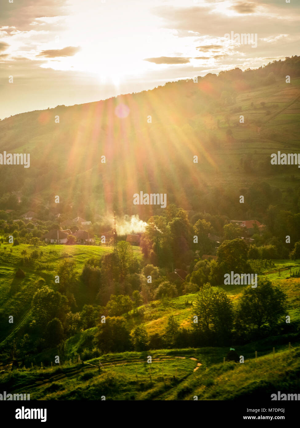 Bright rolling countryside around a farm in the morning light ...