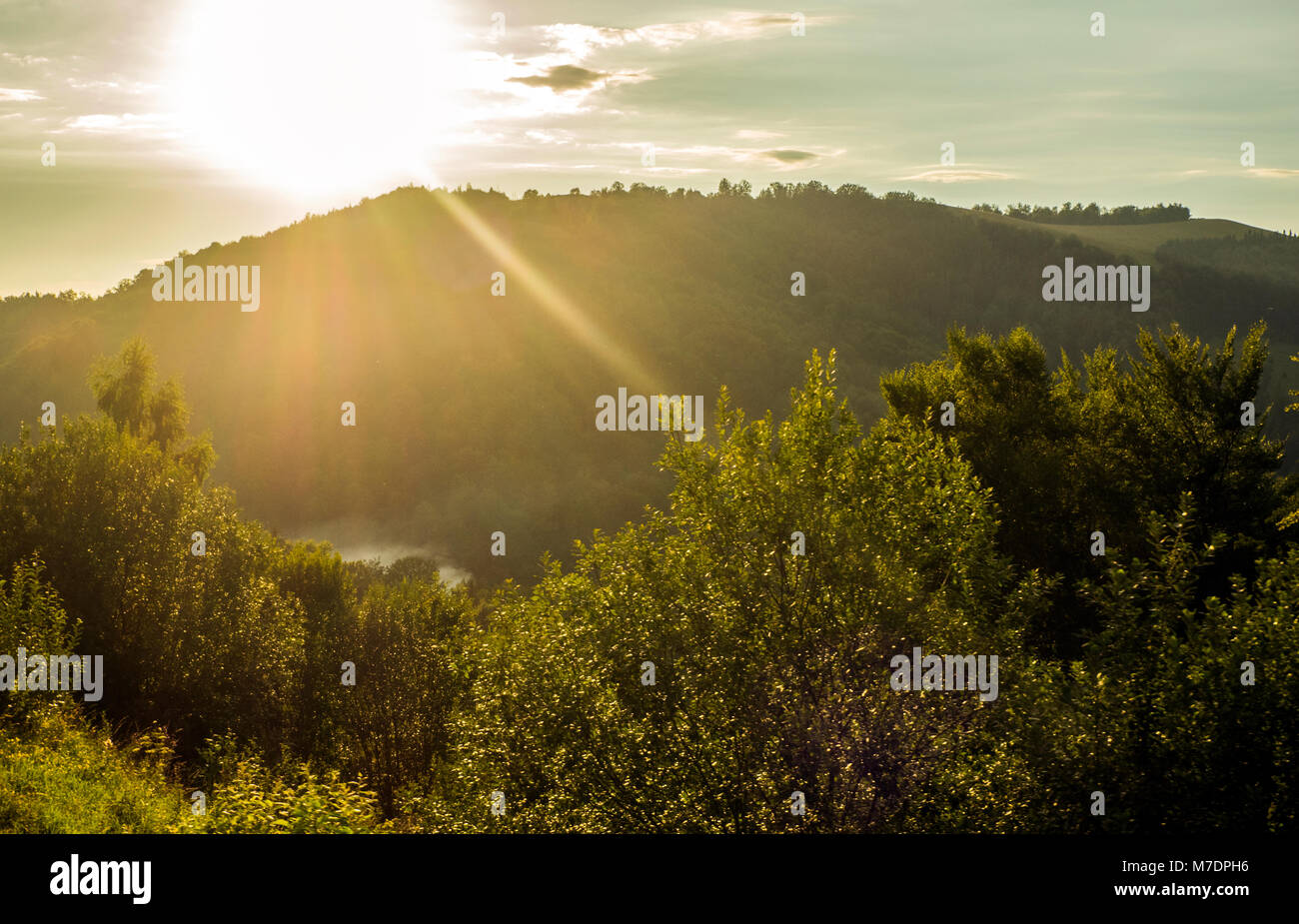 Bright rolling countryside around a farm in the morning light ...