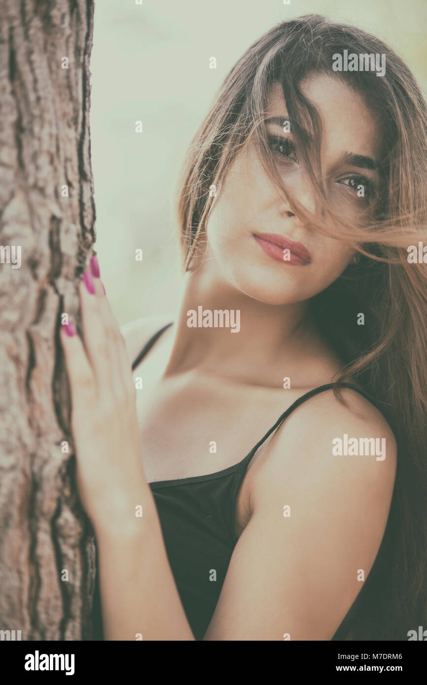 Beautiful young woman hair covering face looking away Stock Photo - Alamy