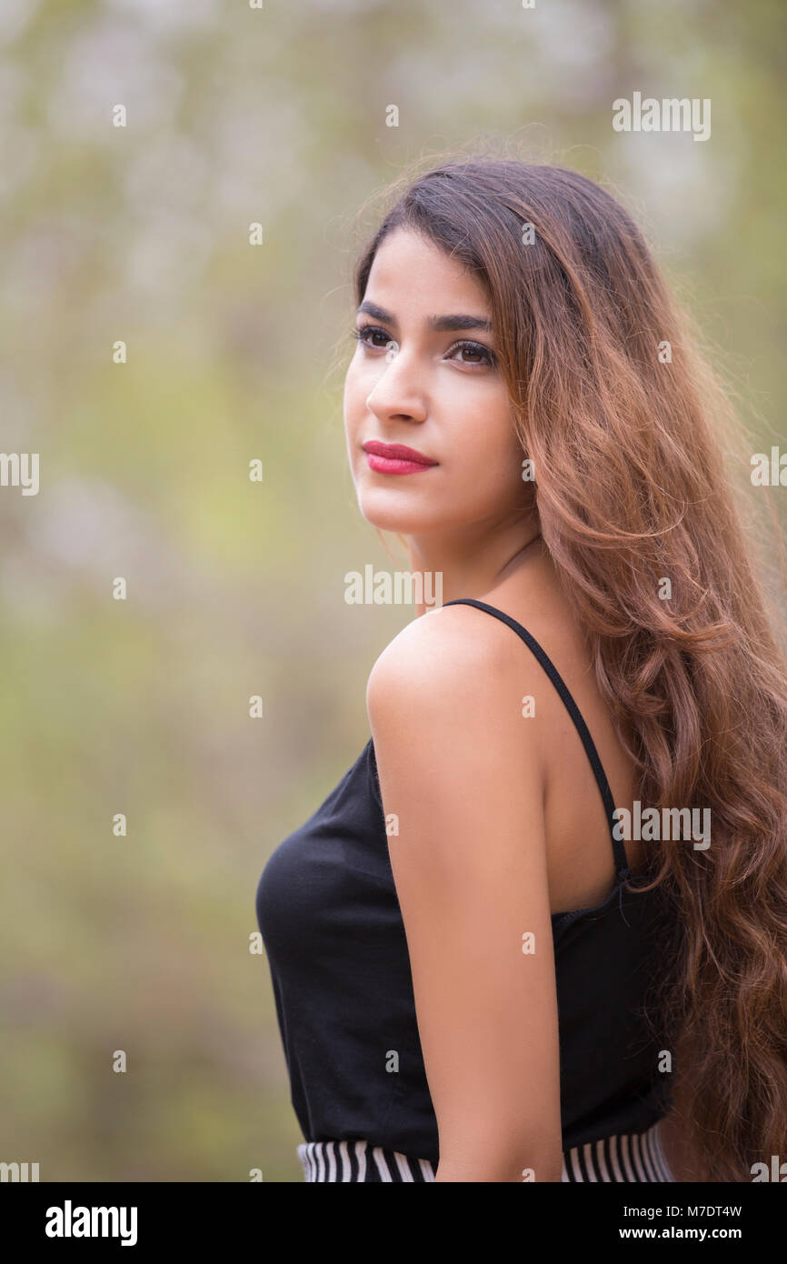 Portrait of a young woman looking over shoulder outdoors Stock Photo ...