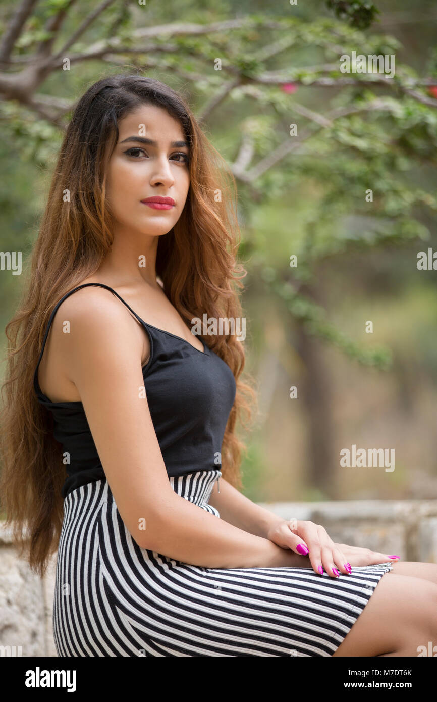 Beautiful young woman sat outdoors Stock Photo - Alamy