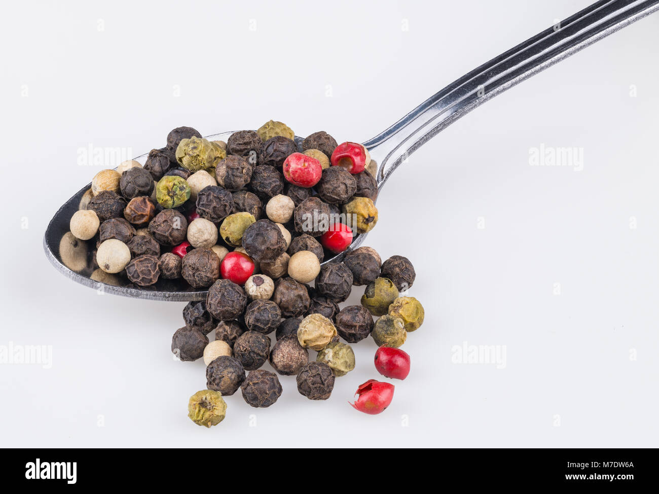 Close-up a spoonful of spicy peppercorns. Piper nigrum. The colorful ...