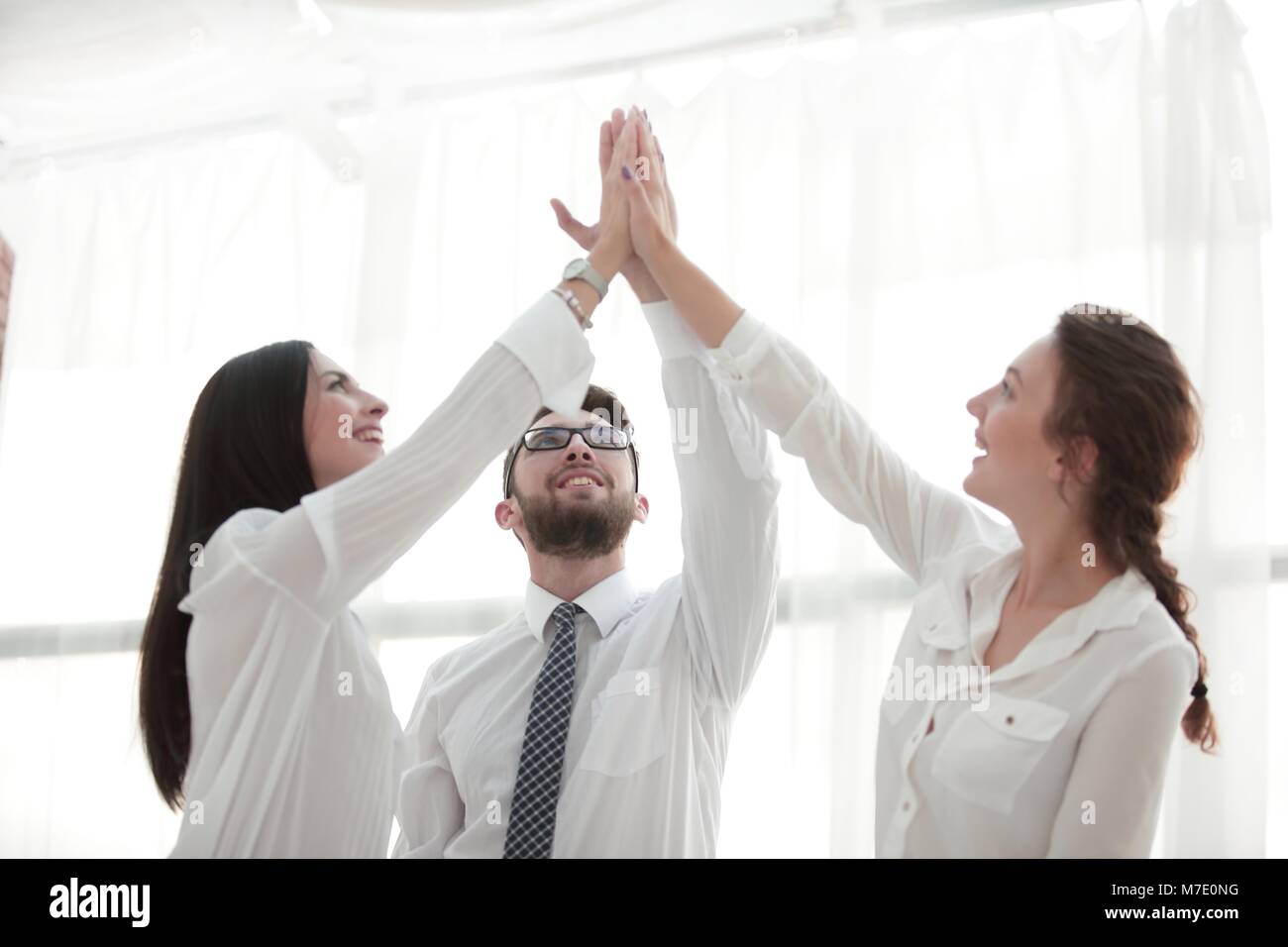 happy colleagues giving each other a high five Stock Photo - Alamy