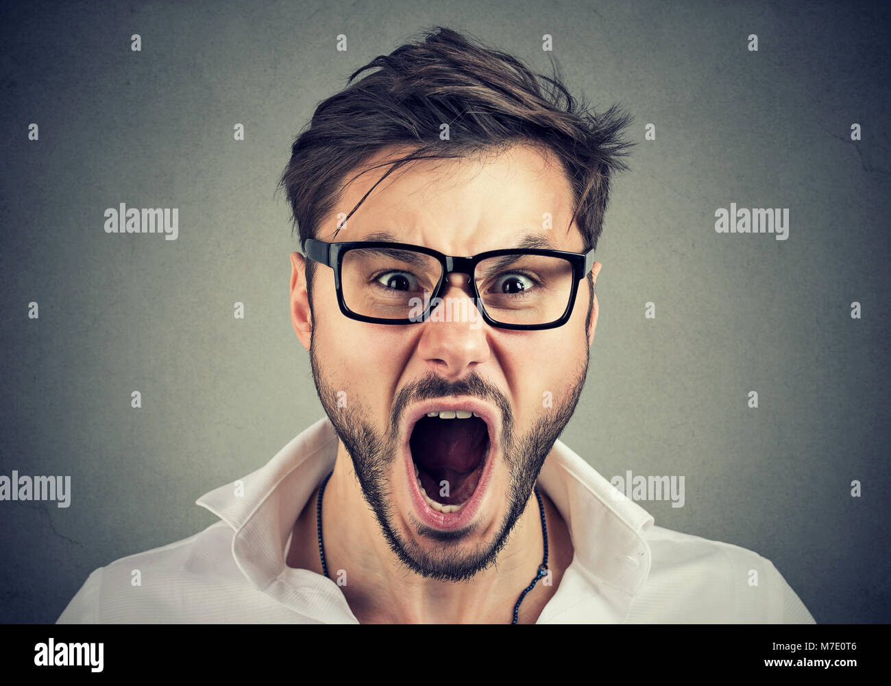 Young bearded man looking at camera and screaming in frustration Stock ...