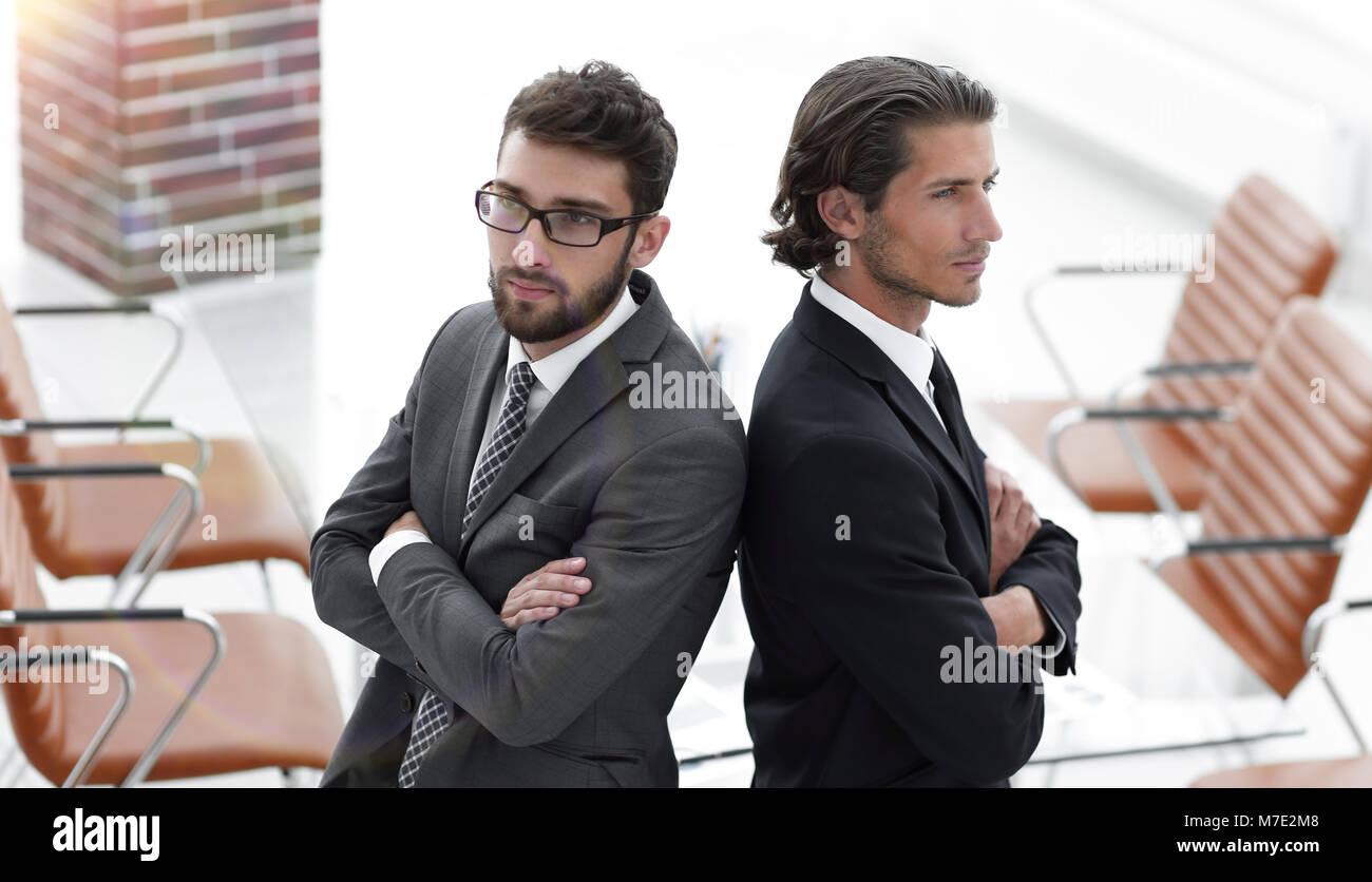 Two men standing back to back and support each other Stock Photo - Alamy
