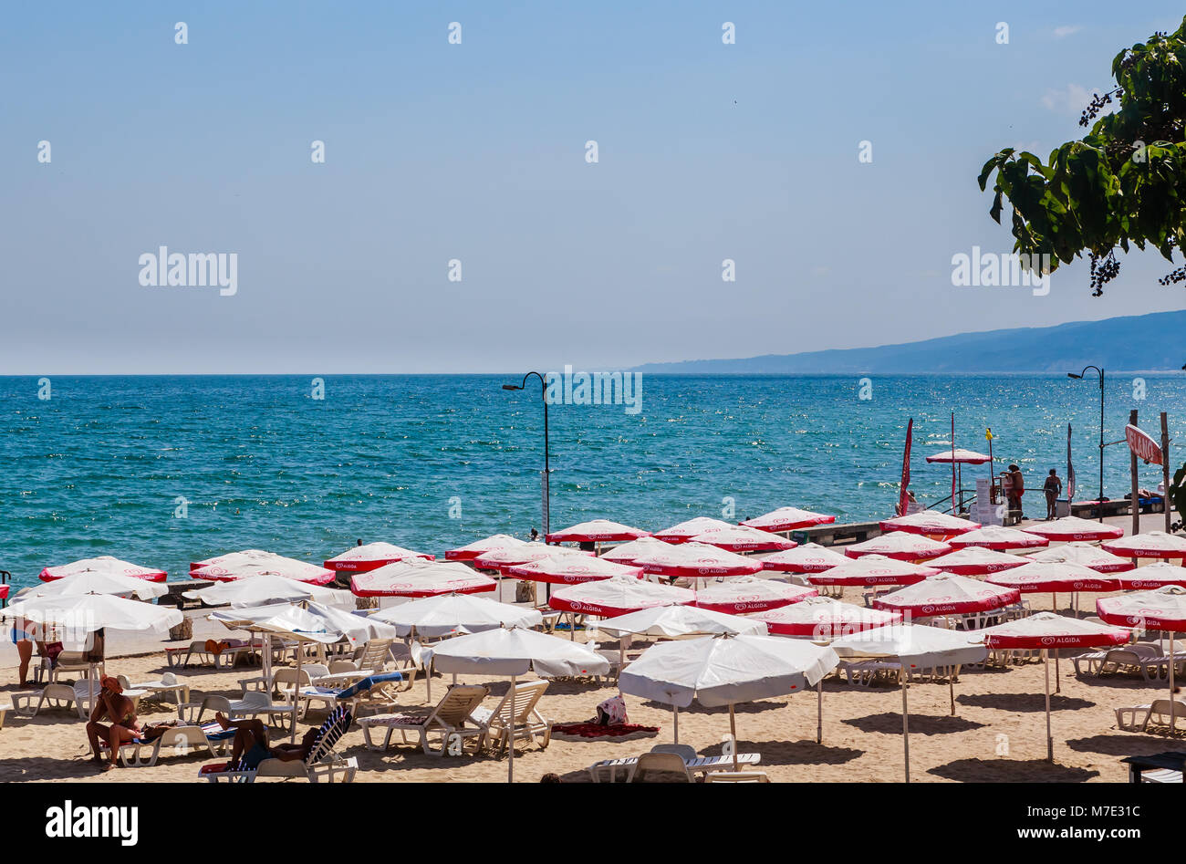The Balchik seaside, beach with sands, sun umbrellas and blue water ...