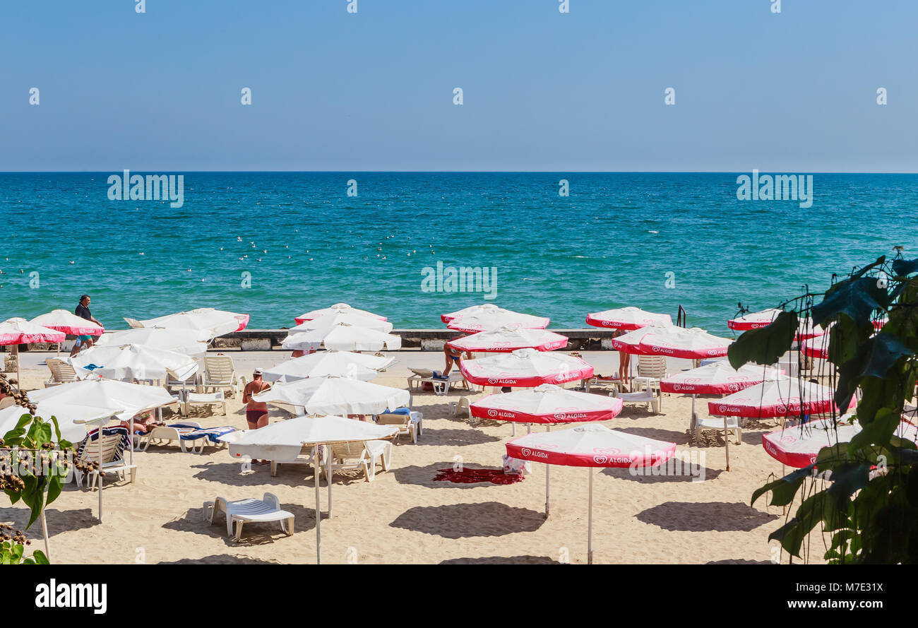 The Balchik seaside, beach with sands, sun umbrellas and blue water ...