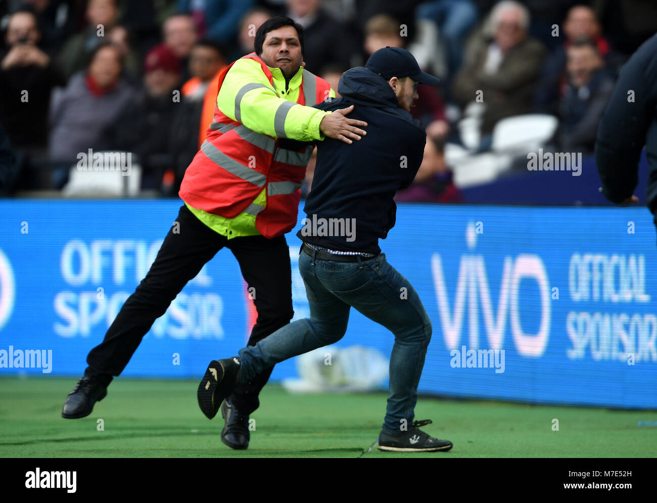 A pitch invader is confronted by security during the Premier League ...