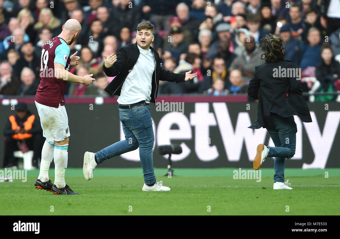 Pitch invaders run onto the pitch during the Premier League match at ...