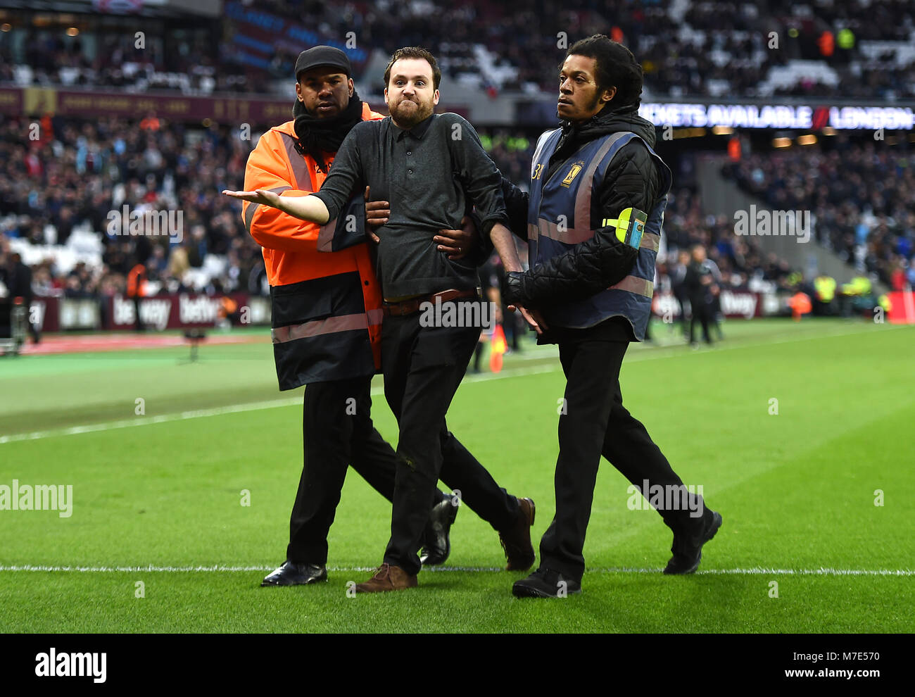 A Pitch invader is confronted by security during the Premier League ...