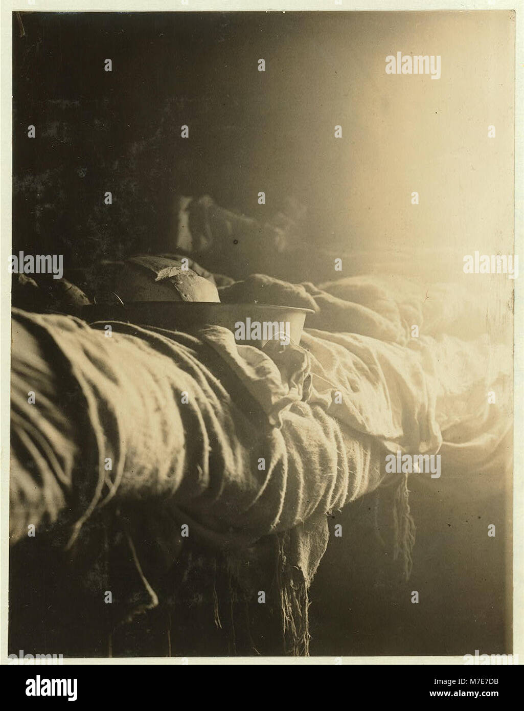 This image depicts a small, poorly maintained bedroom in a large shack ...