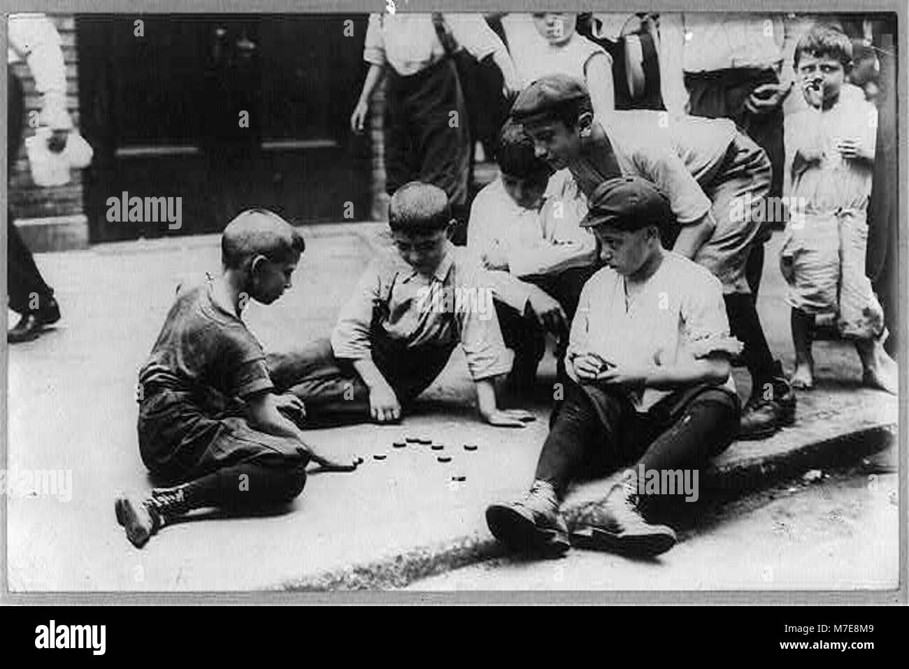 A street scene in New York City featuring boys playing checkers on the ...
