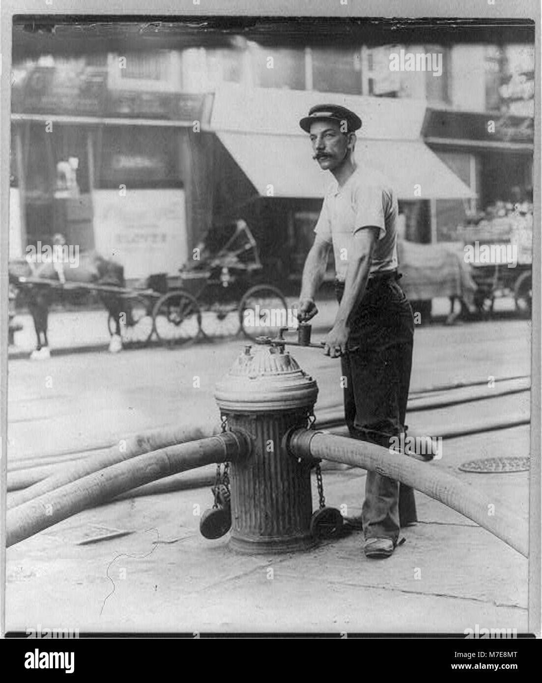 A dramatic photograph of a New York City fireman in July 1908, turning ...