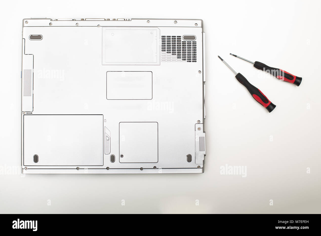 Back side of a modern laptop computer with precision tools lying on a ...