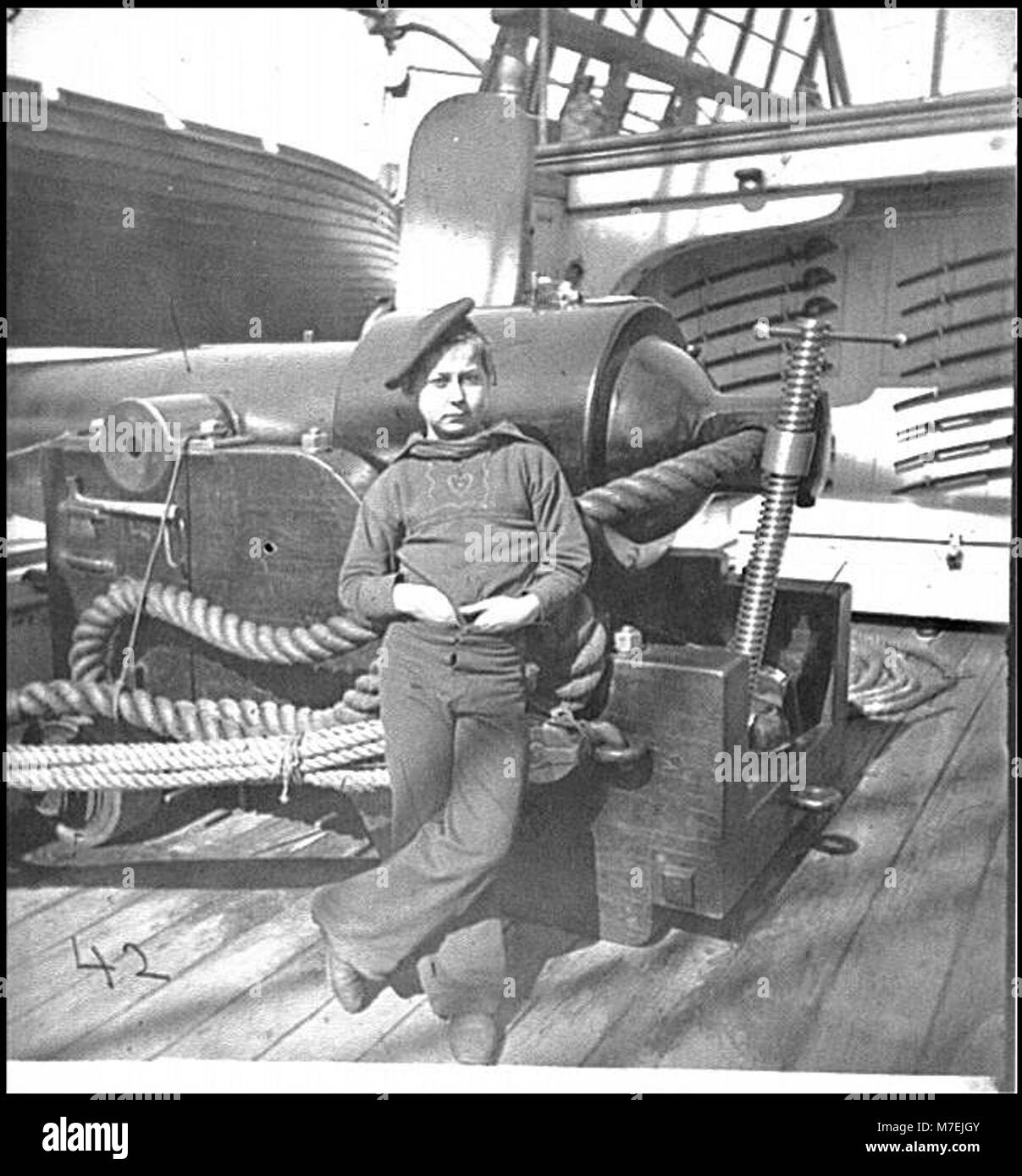 A photograph of a young powder monkey standing next to a gun on the U.S ...