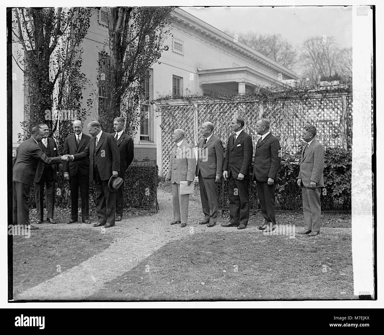 This photograph shows President Herbert Hoover with a group, capturing ...