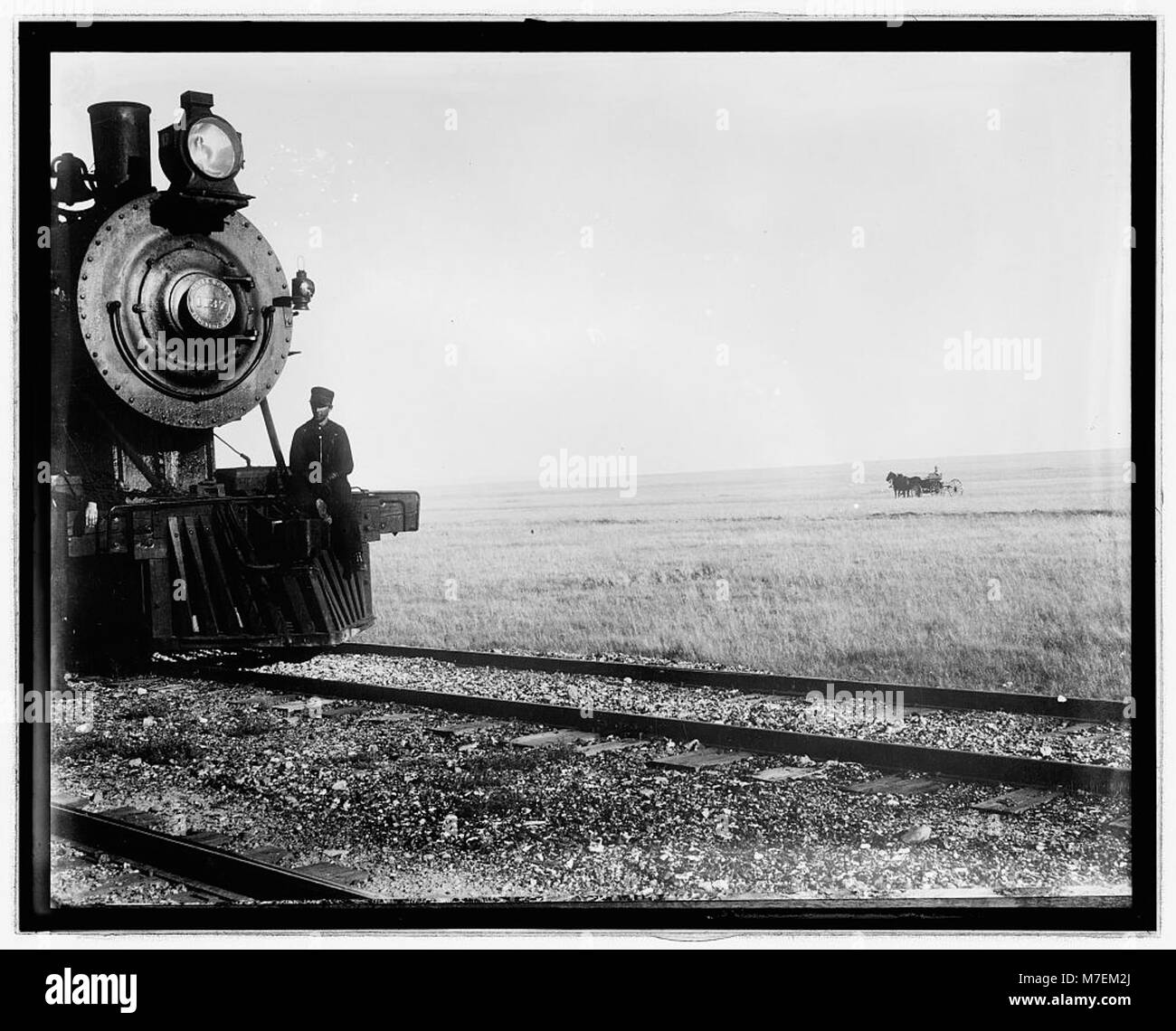 A photograph of a railroad cutting through a rural landscape ...
