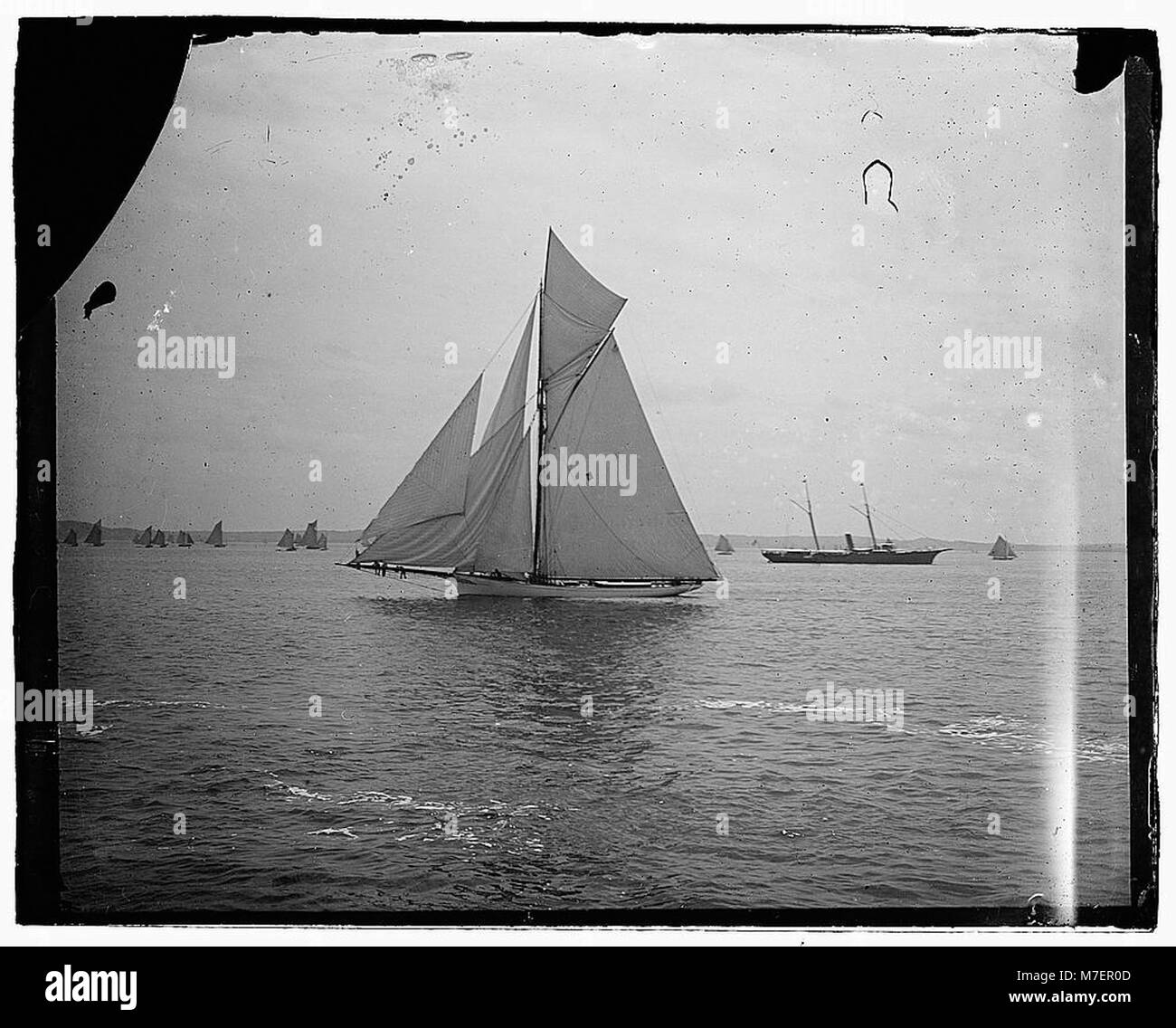 A photograph capturing a sailboat navigating through calm waters ...