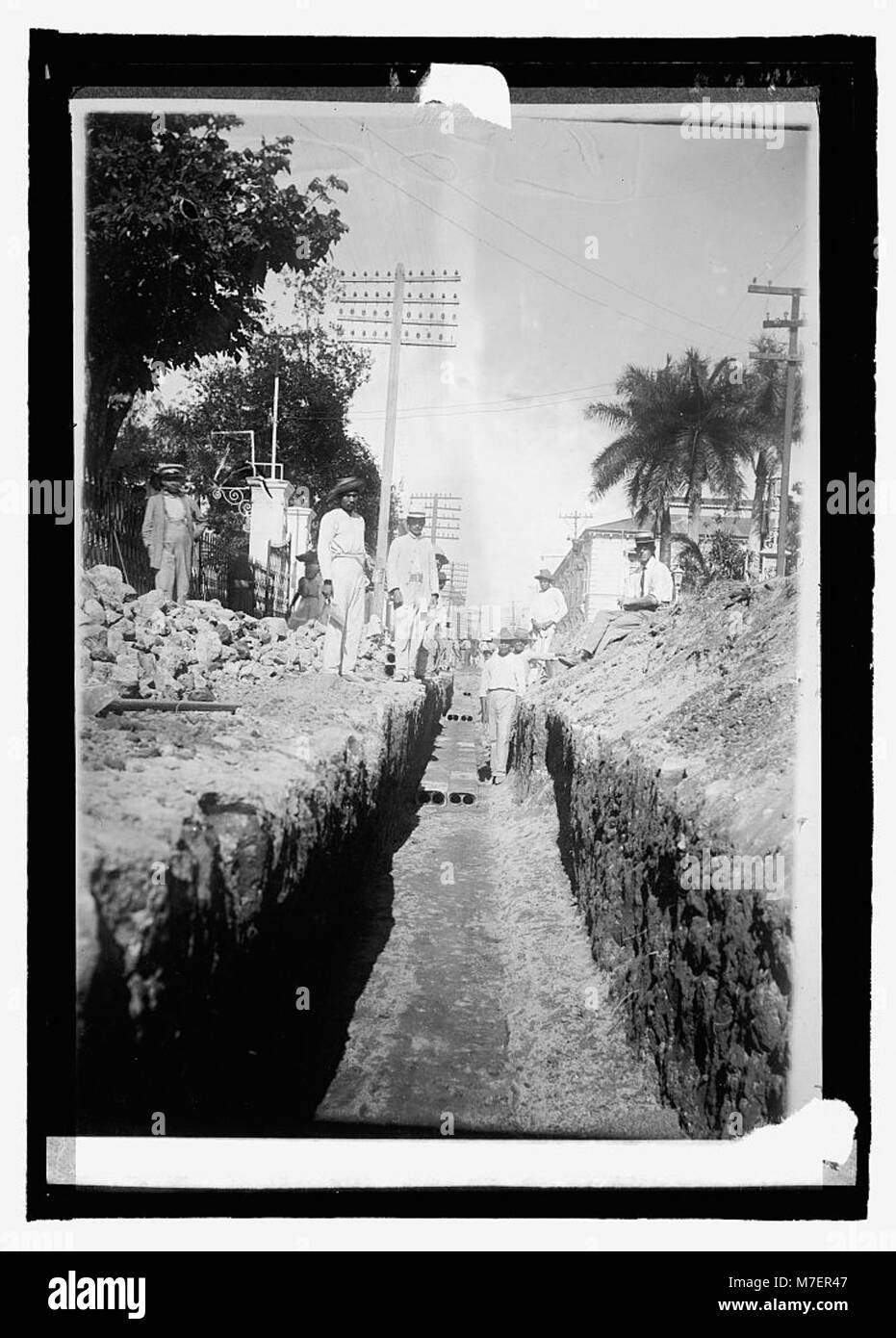 A laborer lays telephone wires in San Salvador, capturing the work of ...