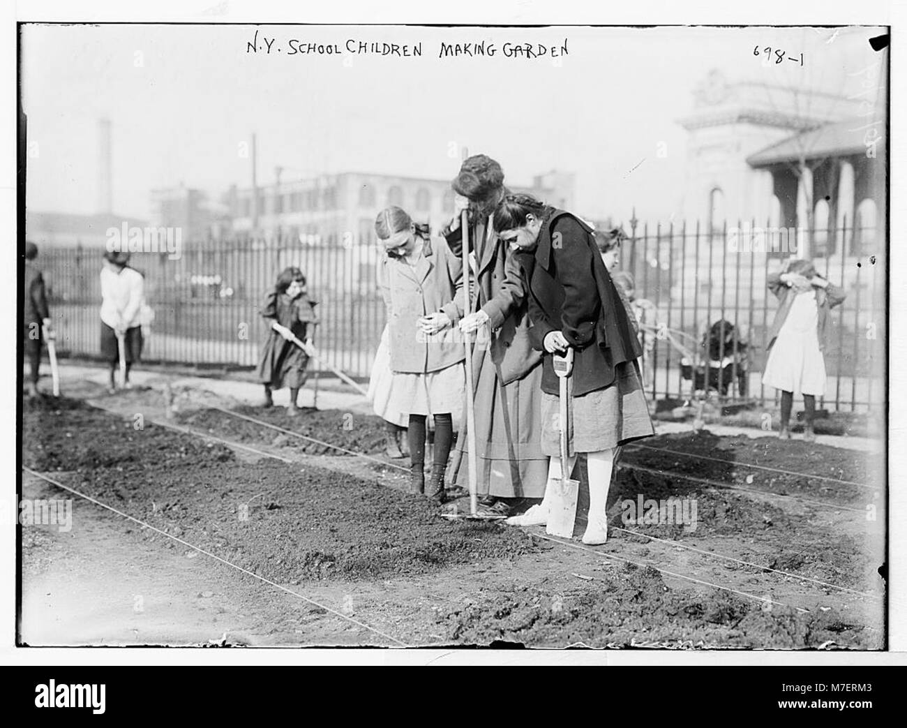 A photograph showing school children working outside, digging and ...