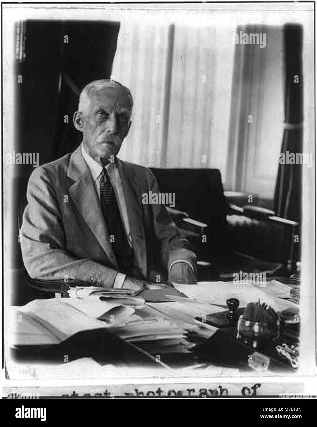 This image depicts Secretary of the Treasury Andrew Mellon seated at ...
