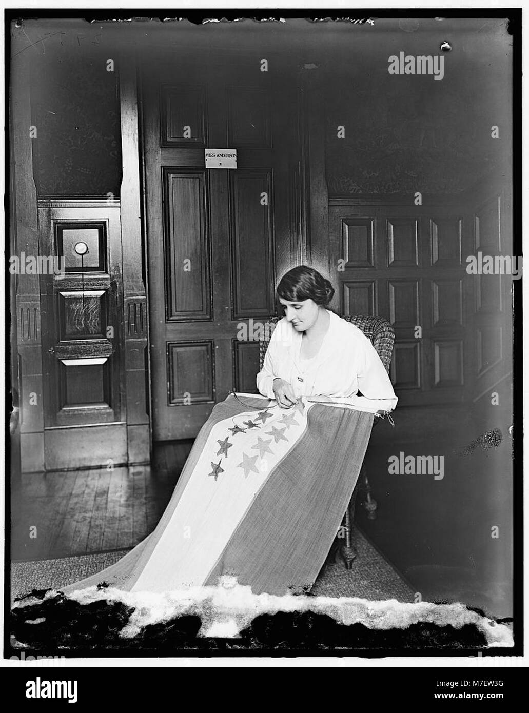 This photograph shows women sewing stars onto a suffrage flag ...