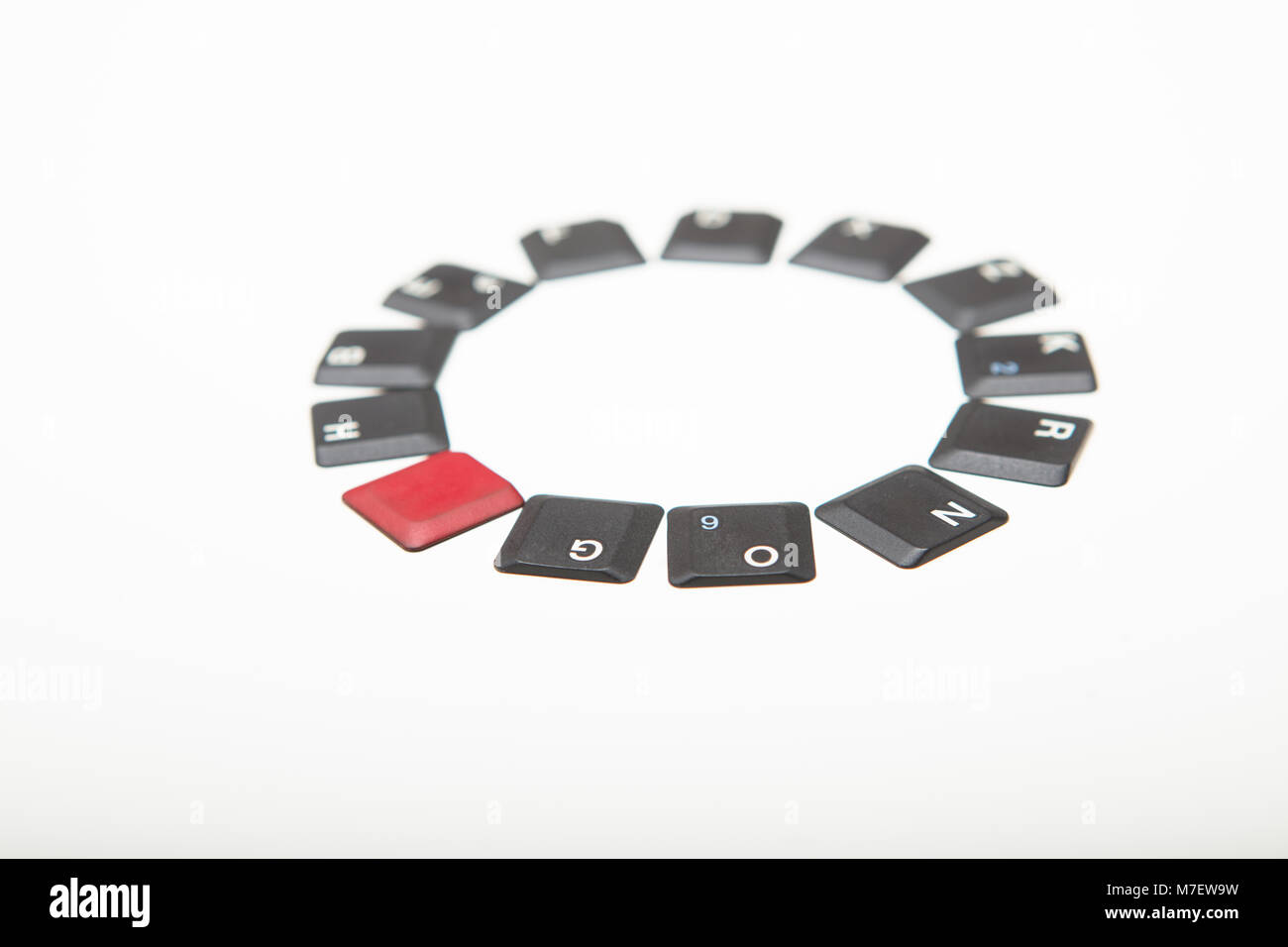 Neat circle of loose grey keyboard key covers with a single red cover ...