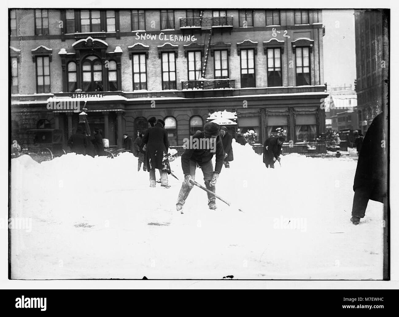 A photograph of workers shoveling snow in New York, capturing the ...