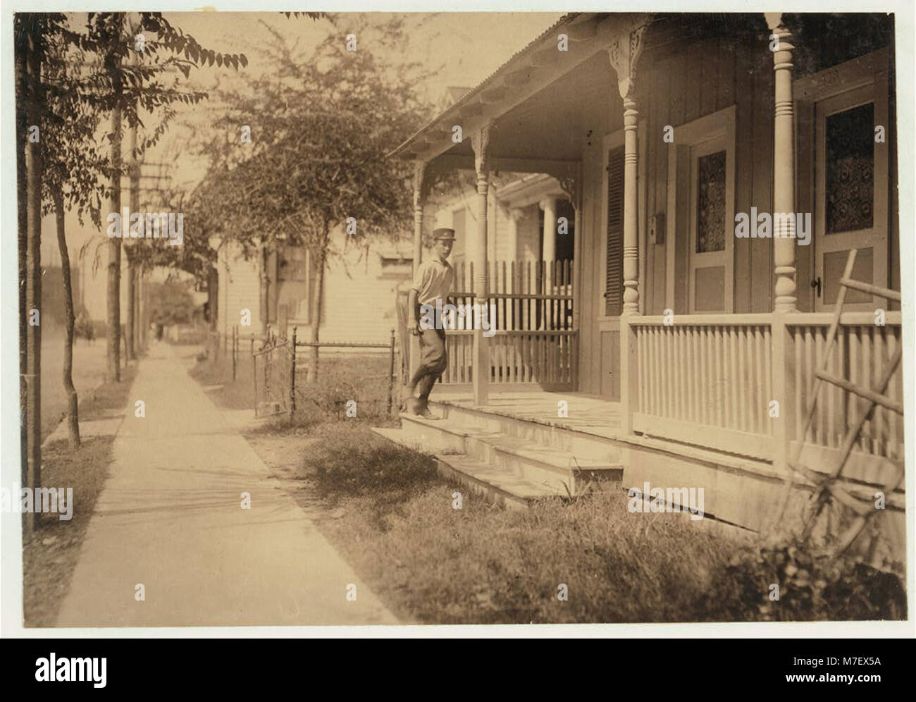 Photograph of a sixteen-year-old messenger boy entering a building in a ...